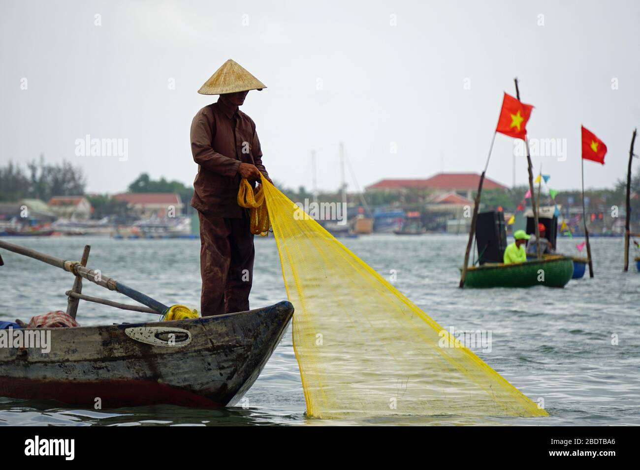 vietnamese fisherman on small boat fishing with fishnet Stock Photo - Alamy