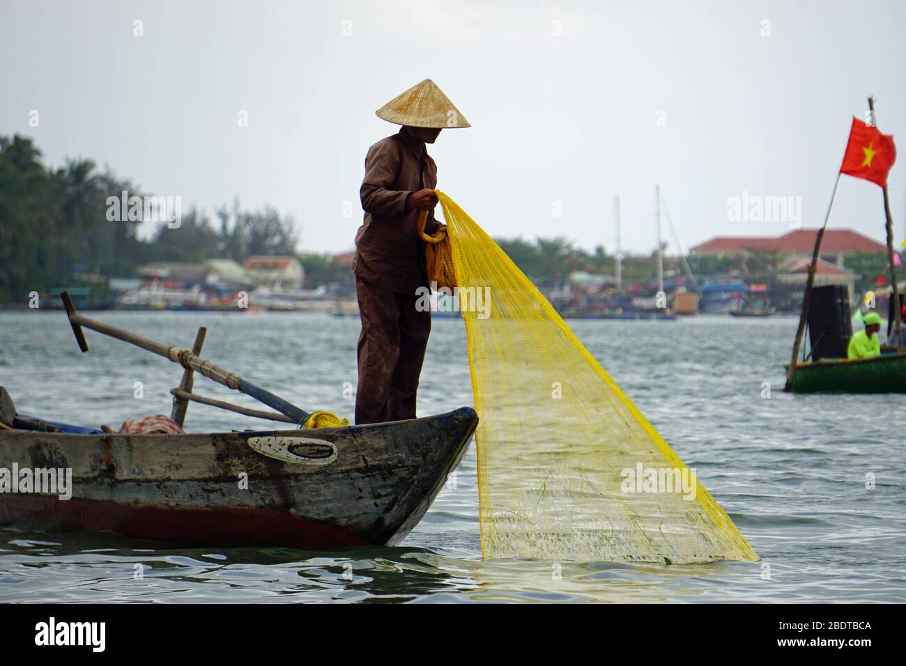 vietnamese fisherman on small boat fishing with fishnet Stock Photo - Alamy
