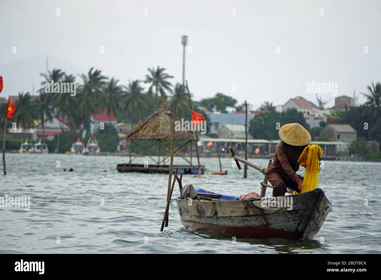 vietnamese fisherman on small boat fishing with fishnet Stock Photo - Alamy