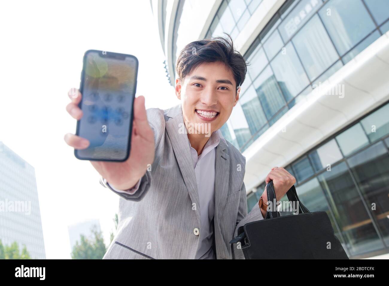 Business men show a mobile phone Stock Photo - Alamy