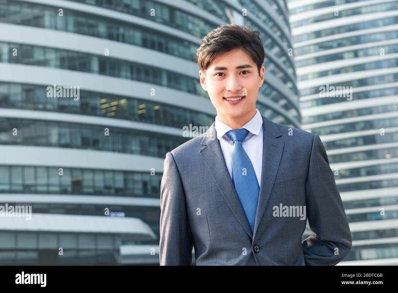 Business man standing in front of the building Stock Photo - Alamy