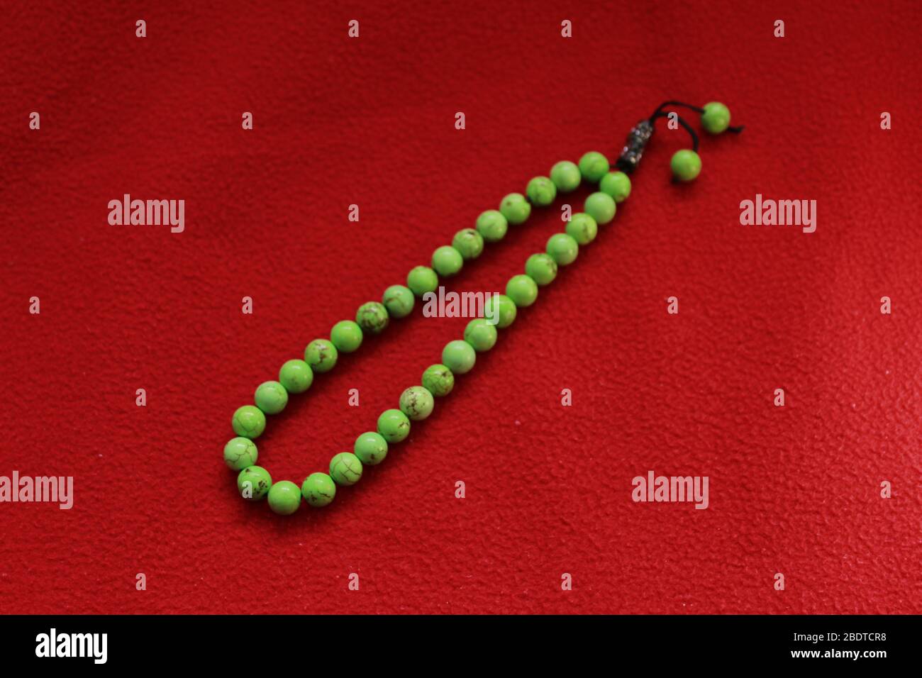green color praying beads on red background Stock Photo - Alamy