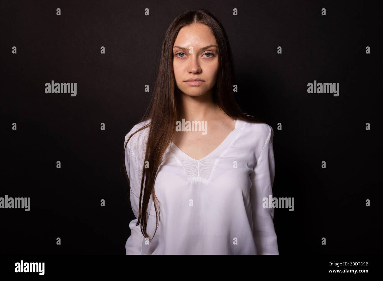 Beautiful caucasian girl with clear no makeup skin looking seriously at ...