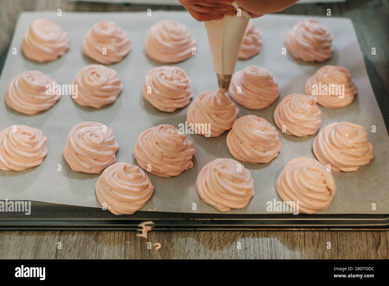 Homemade pink marshmallows on baking paper background on the kitchen ...