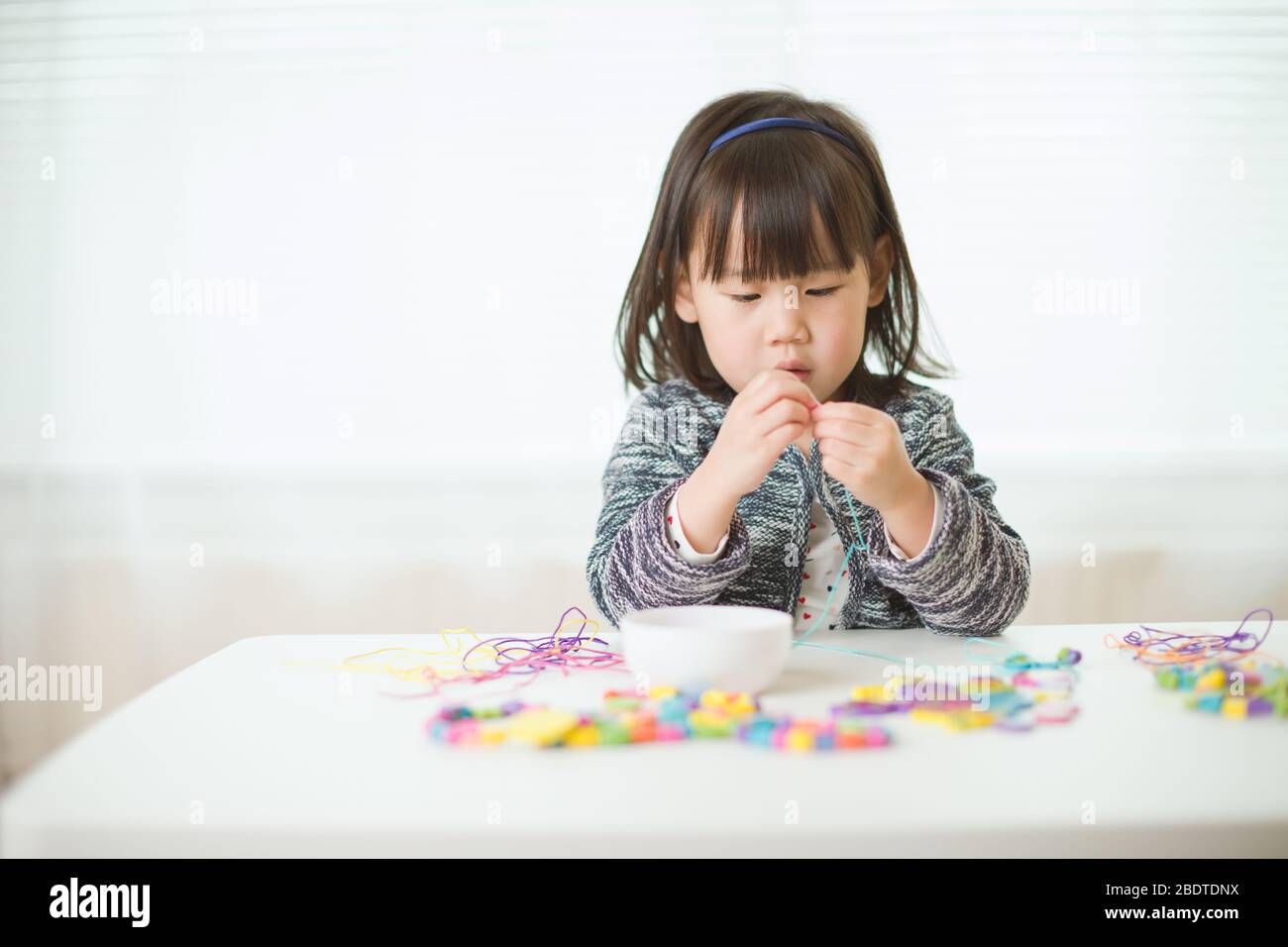 toddler girl string wooden bead crafts for homeschooling Stock Photo ...