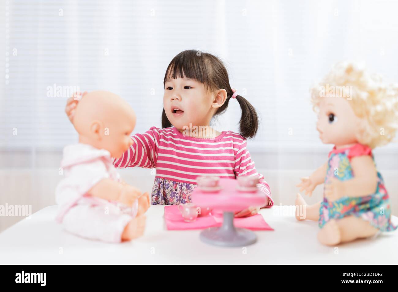 Toddler feeding baby doll hi-res stock photography and images - Alamy
