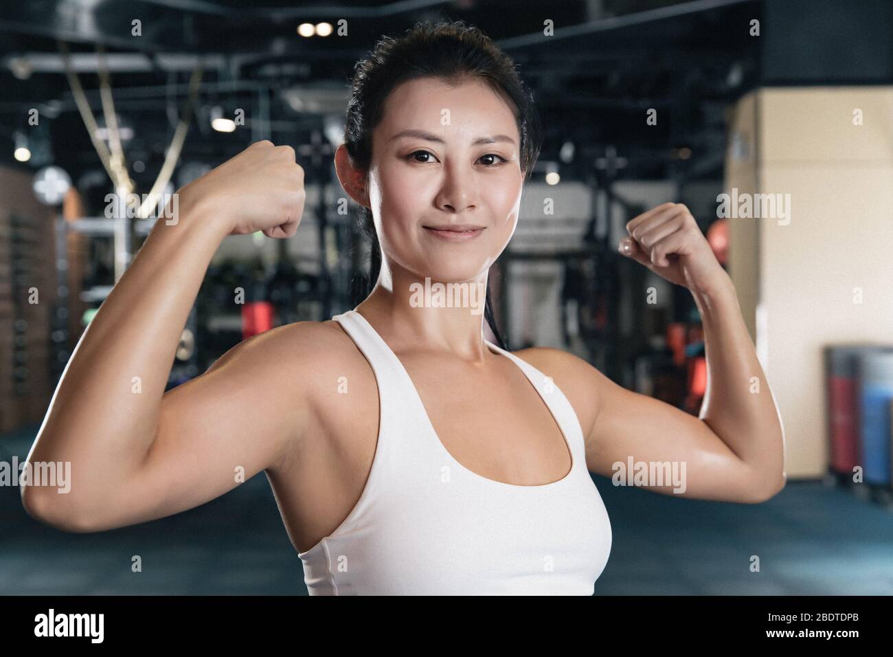 Young women show muscles in the gym Stock Photo - Alamy