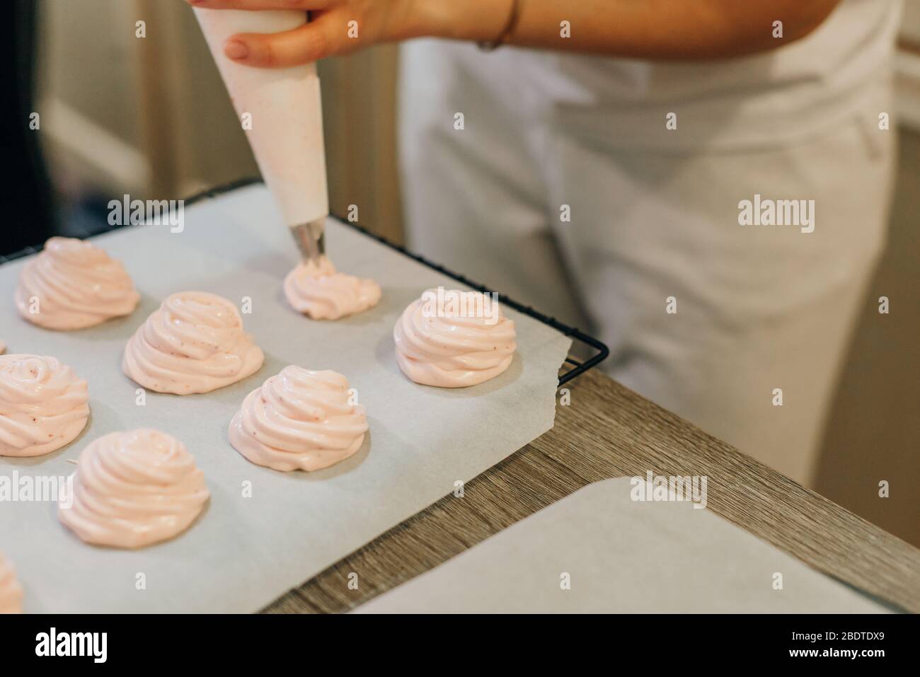 Homemade pink marshmallows on baking paper background on the kitchen ...