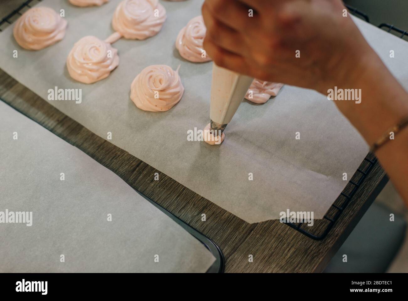 Homemade pink marshmallows on baking paper background on the kitchen ...