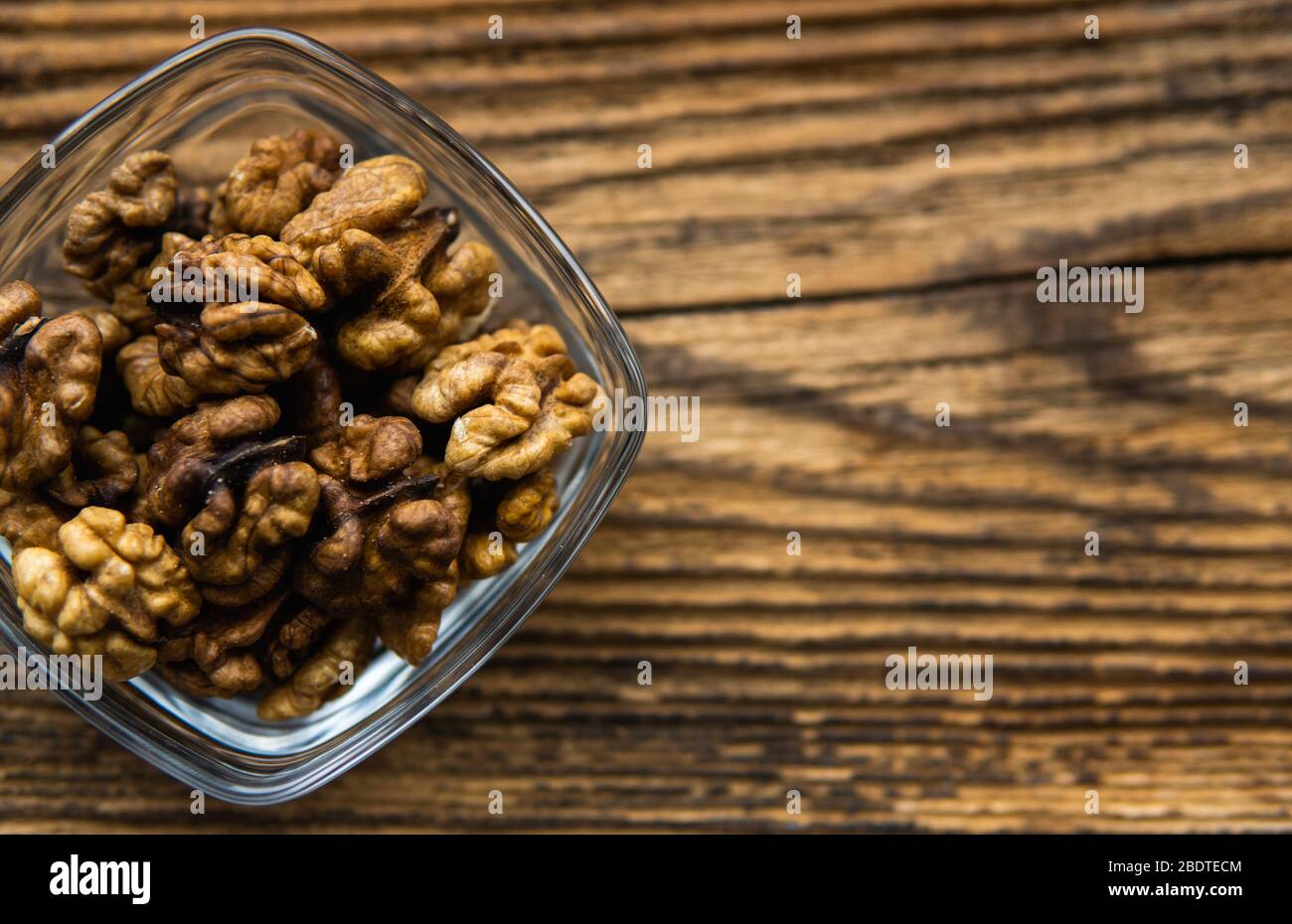 Walnut in a small plate on a vintage wooden table as a background ...