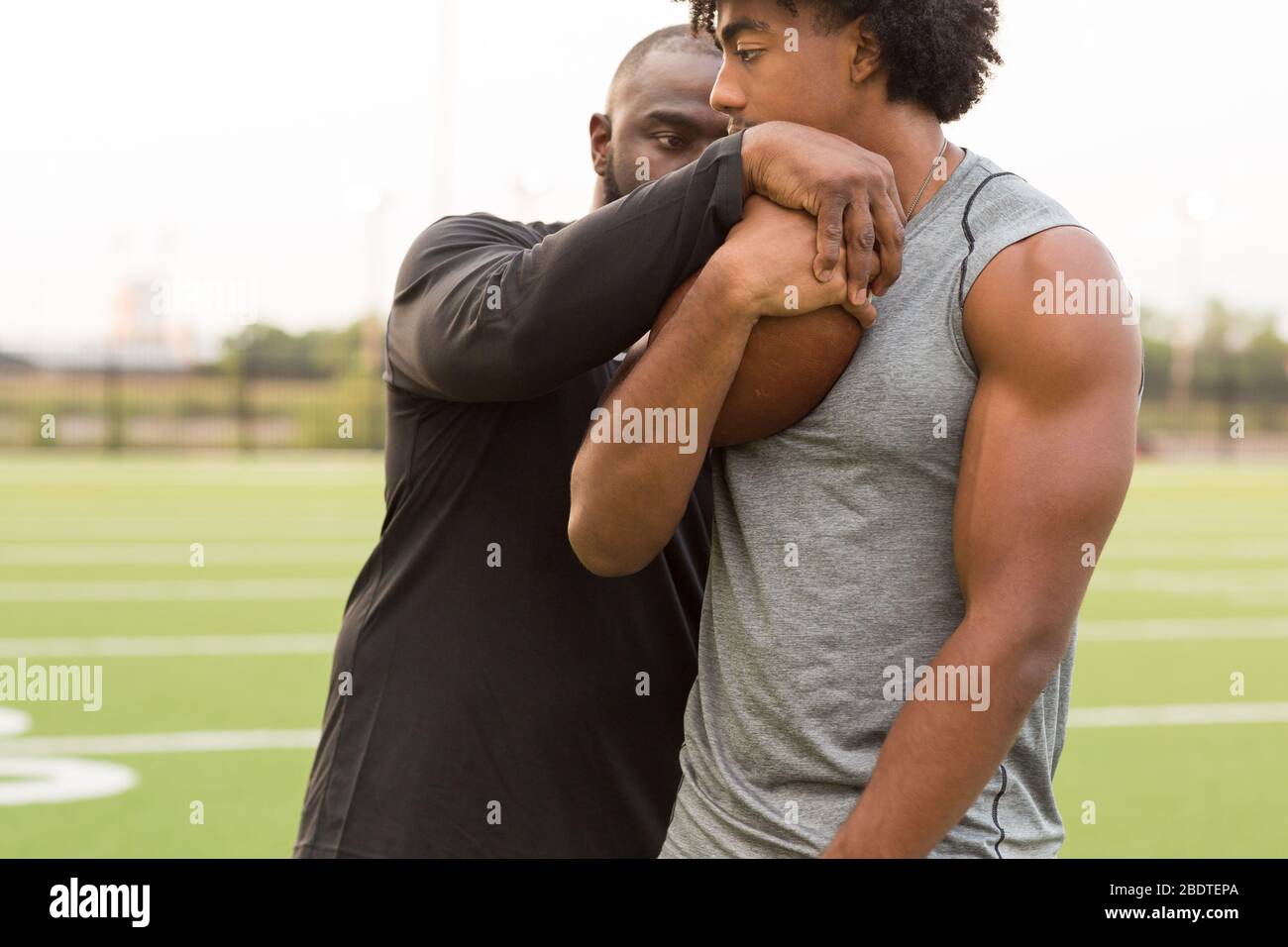 American Football coach training a young athlete Stock Photo - Alamy