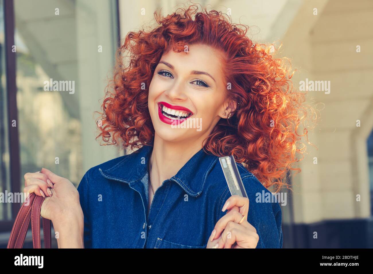 Cheerful smile woman holding showing credit card near clothing ... Cheerful smile woman holding showing credit card near clothing ...