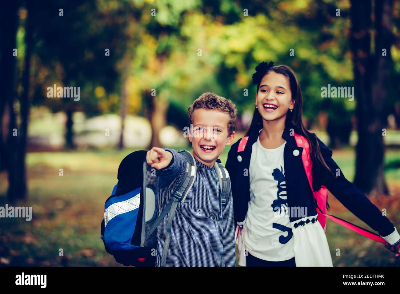 Back to school. Close up two happy friends with backpacks laughing and ...