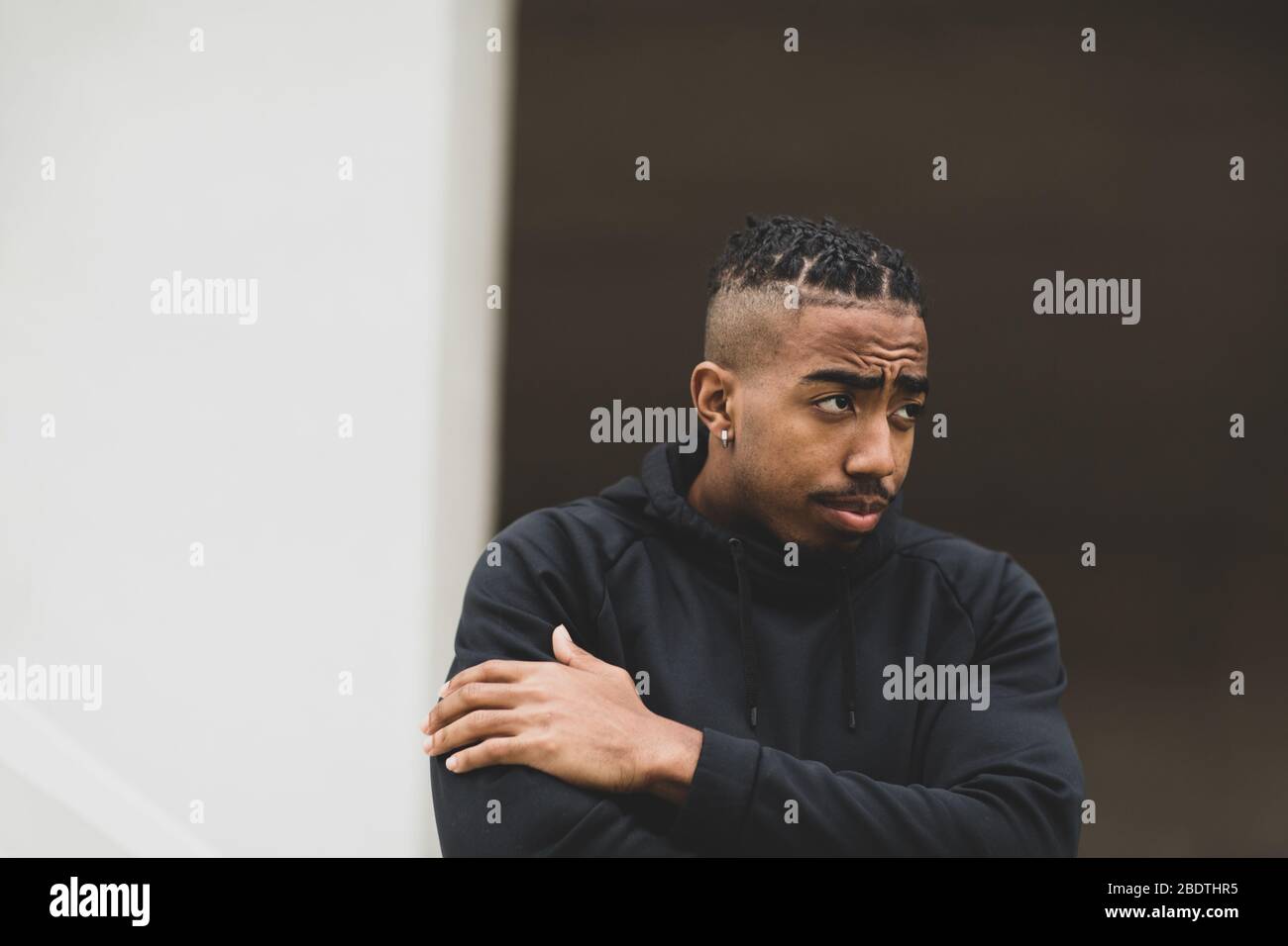 Young African American man outside wearing a hoddie Stock Photo - Alamy