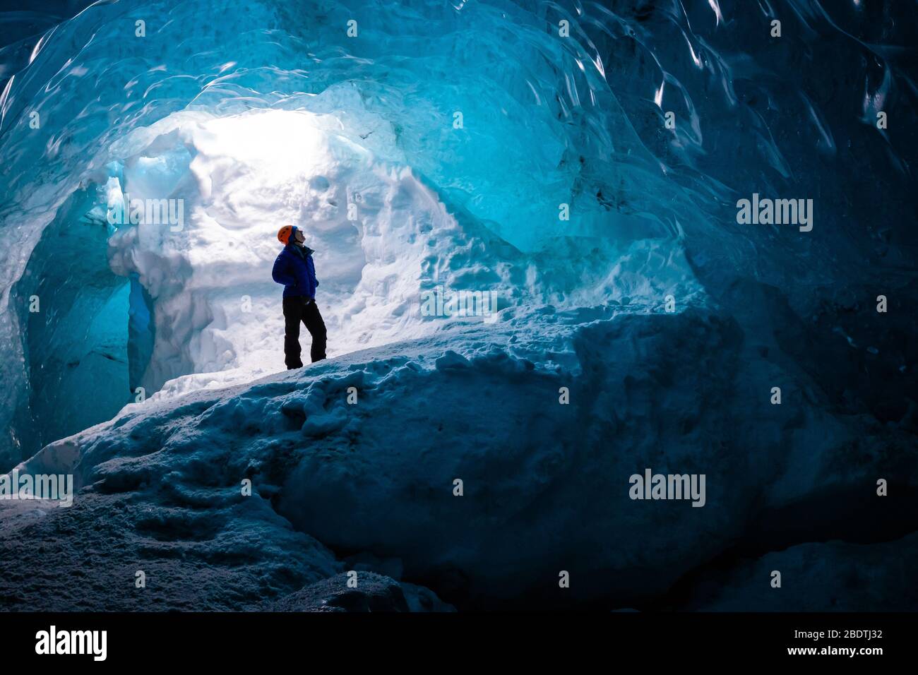 A female explorer in a glacier ice cave, Iceland Stock Photo - Alamy