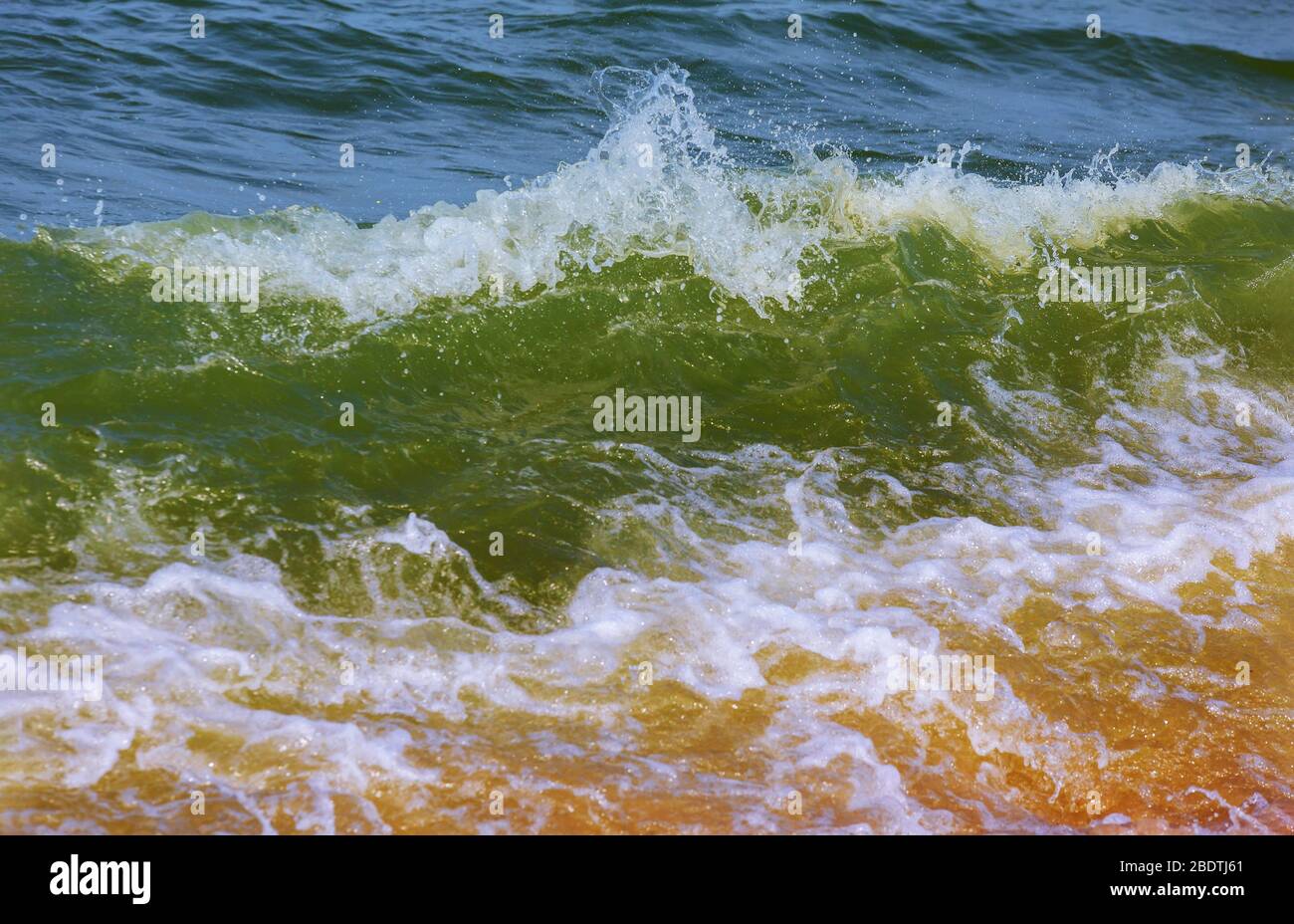 Wave breaking over blue swells crashing curling a surface ocean foamy ...