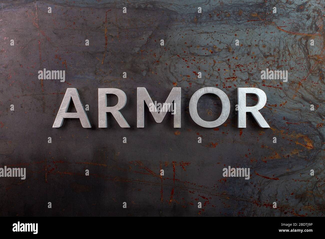 the word armor laid with silver metal letters on rusted black iron flat ...