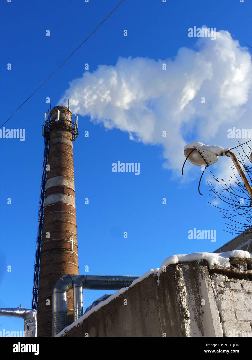 Pipes of an old factory throw clouds of poisonous white smoke into the ...
