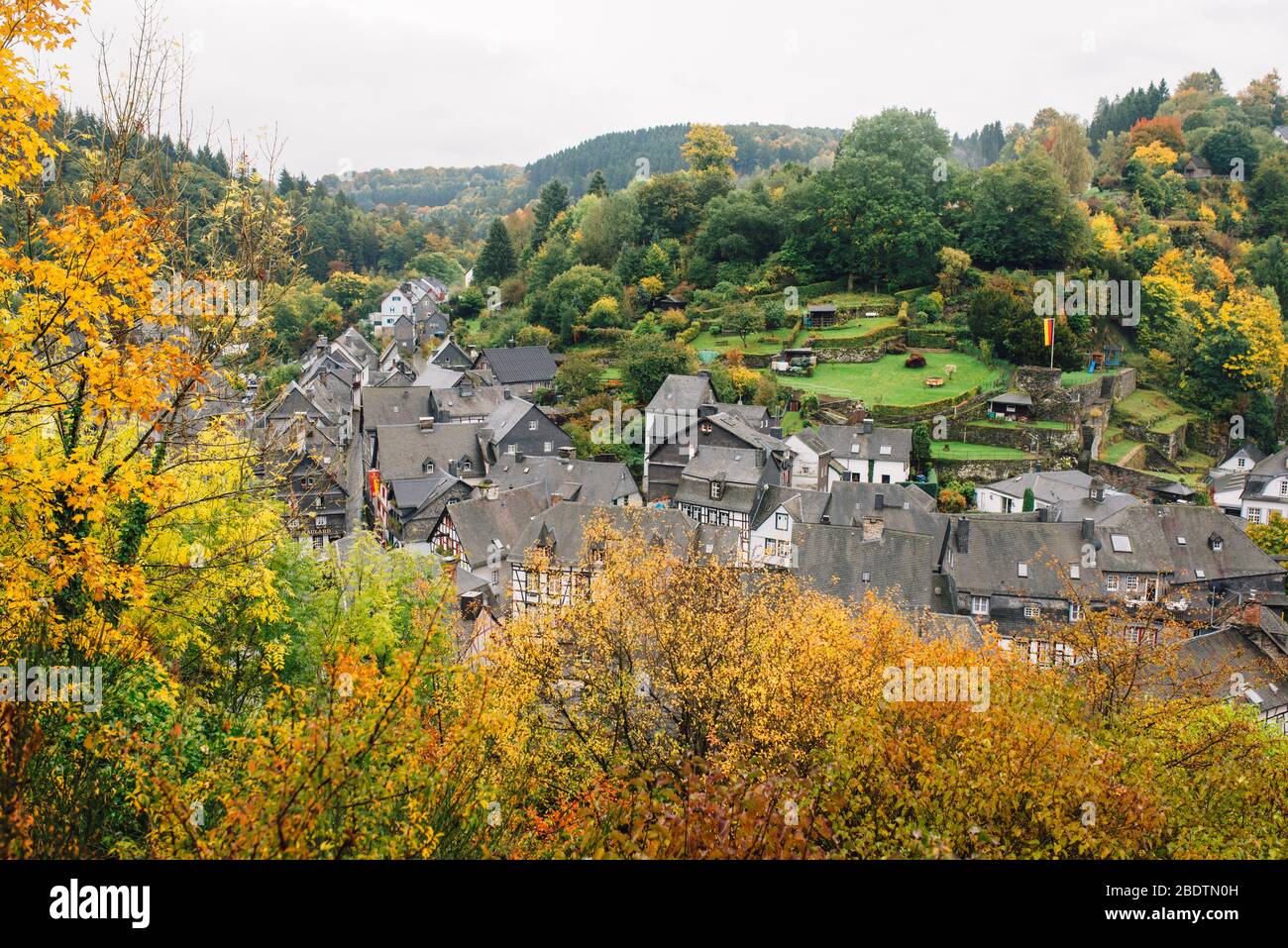 cloudy autumn panorama of the old city. Monschau, Germany. Green hills ...