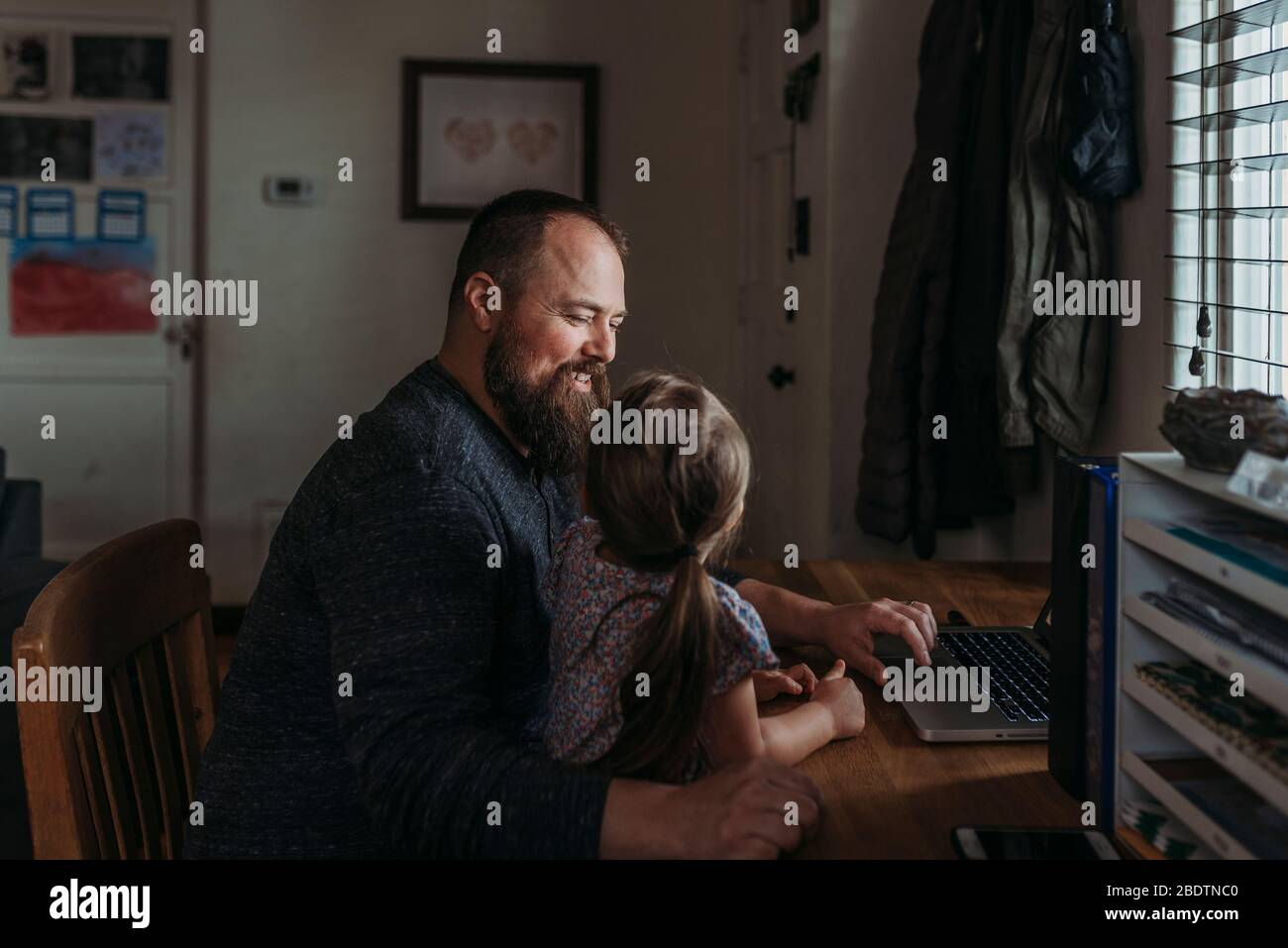 Father with young preschool aged daughter sitting while he works from ...