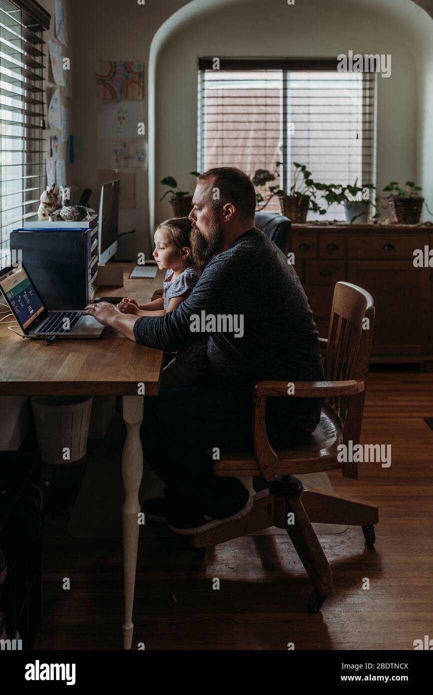 Father with young preschool aged daughter sitting while he works from ...