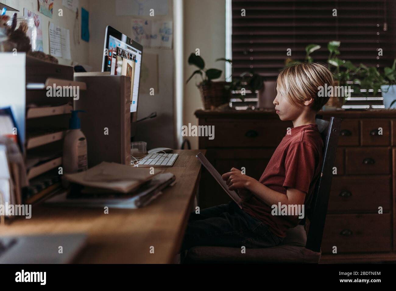School aged boy learning online by video chat during homeschool Stock ...