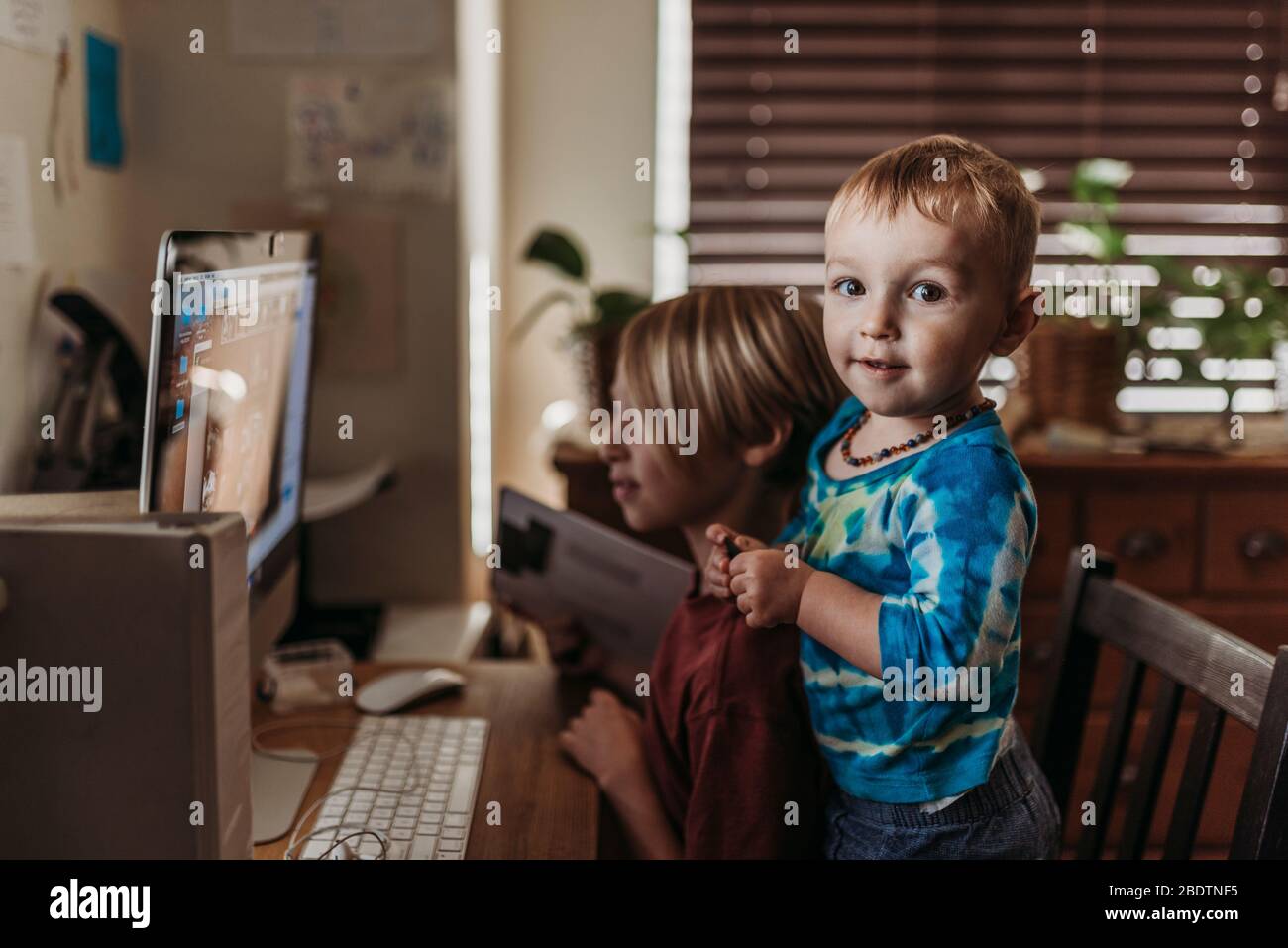 Young siblings video chatting on screen with family during isolation ...