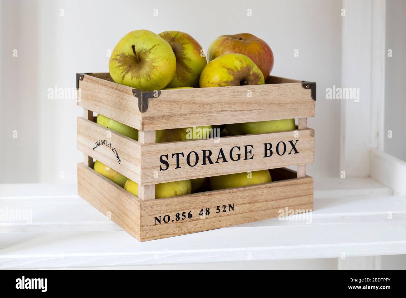 The green apples in the wooden box at the shelf. Concept Stock Photo ...