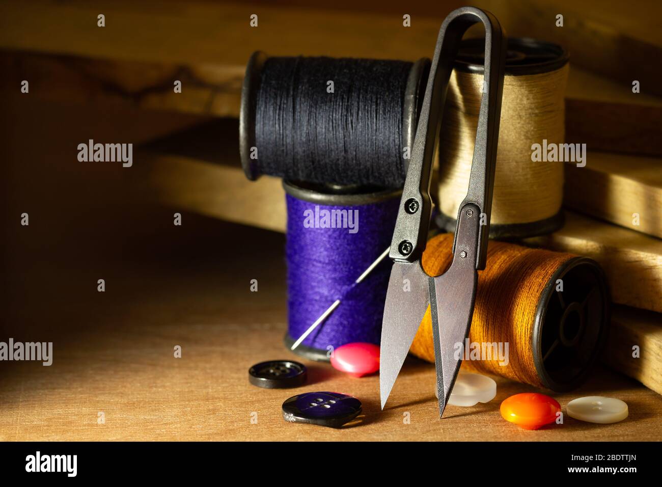 Needle and threads against plastic button and thread cutting scissors ...