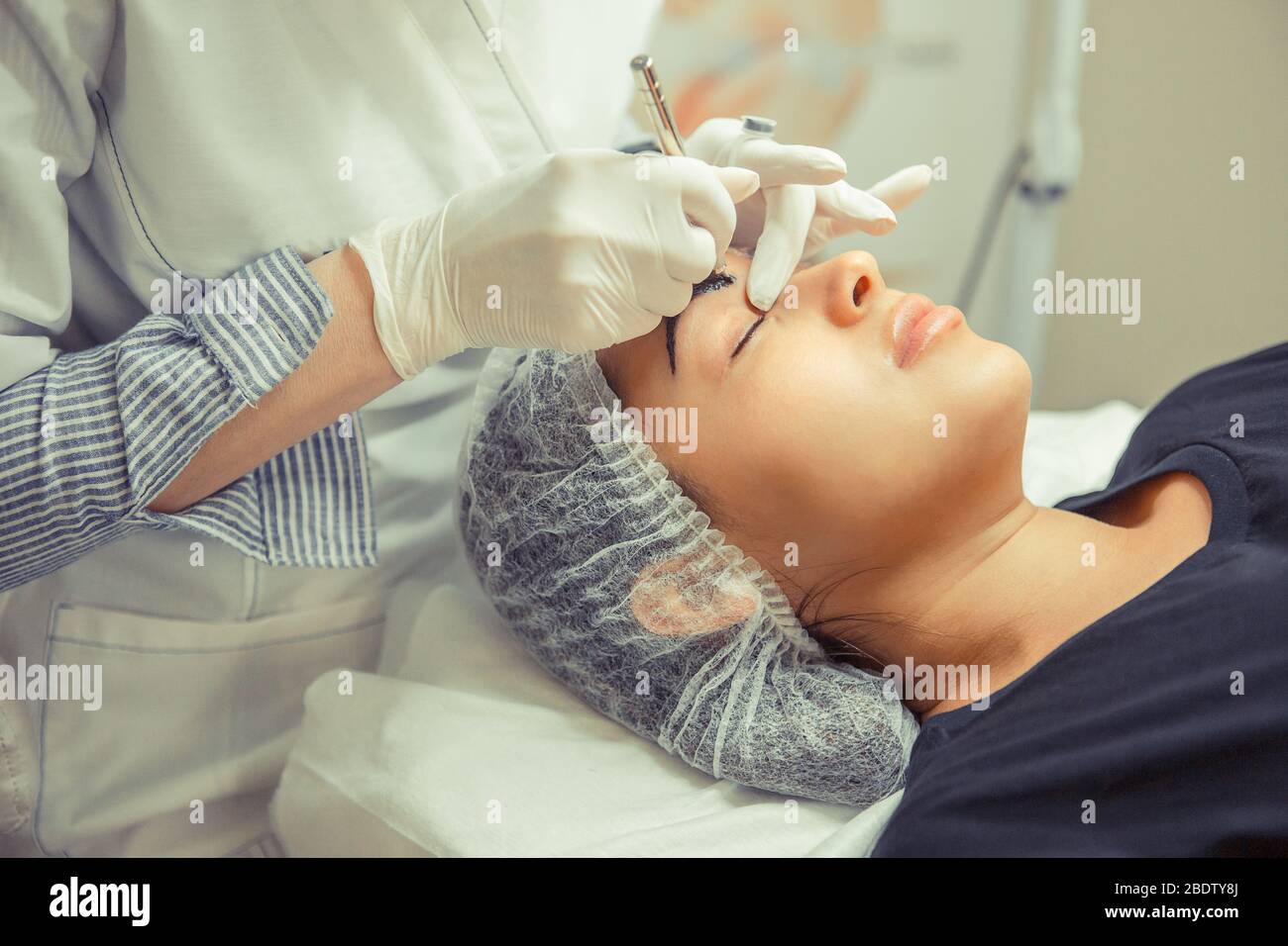 Microblading eyebrows work flow in a beauty salon. Woman having her eye ...