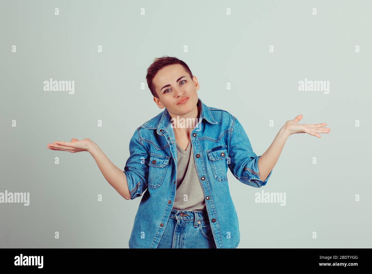 Portrait dumb looking woman arms out shrugs shoulders who cares so what ...