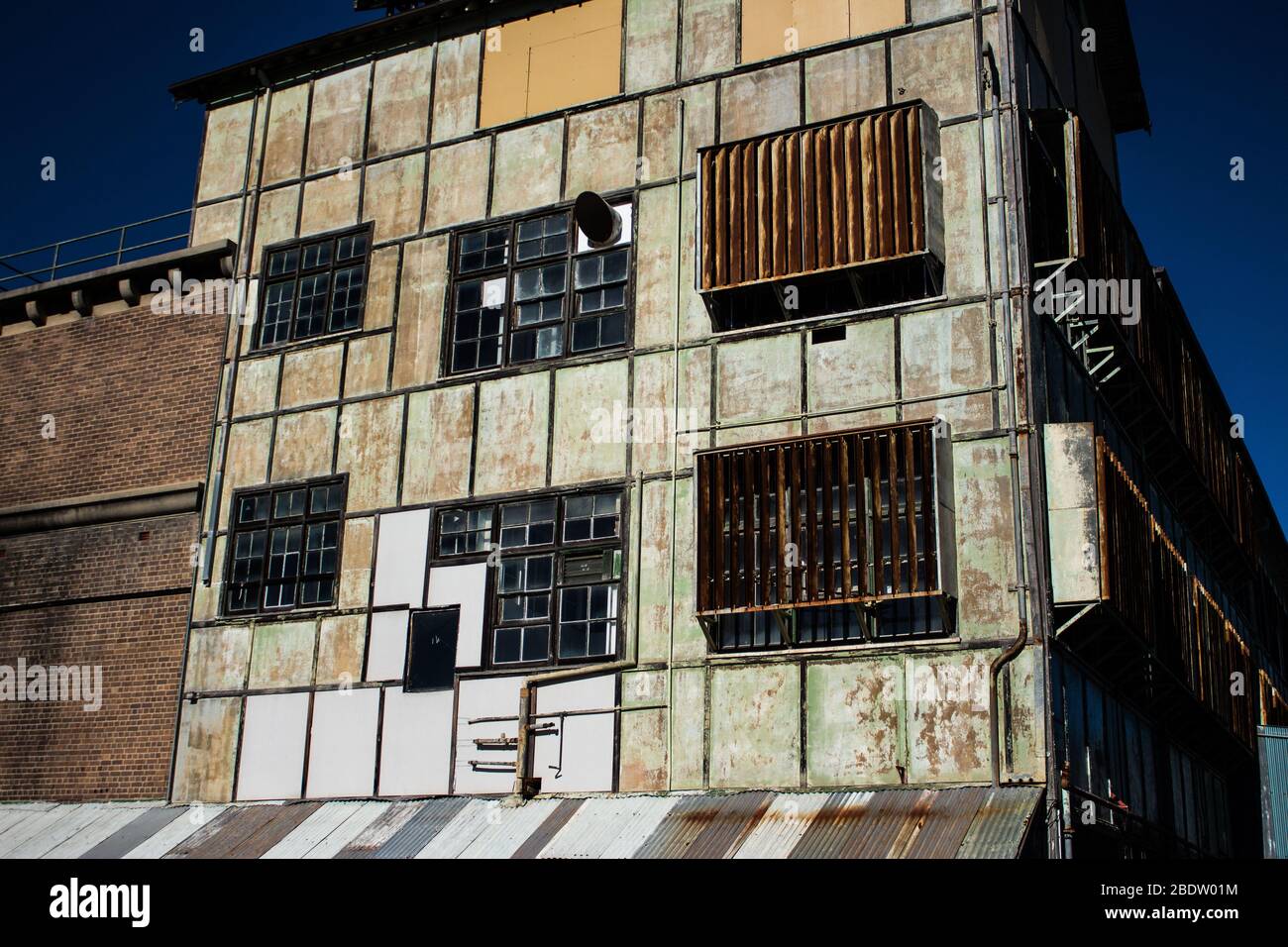 Industrial weathered urban building with rusting window grill and ...
