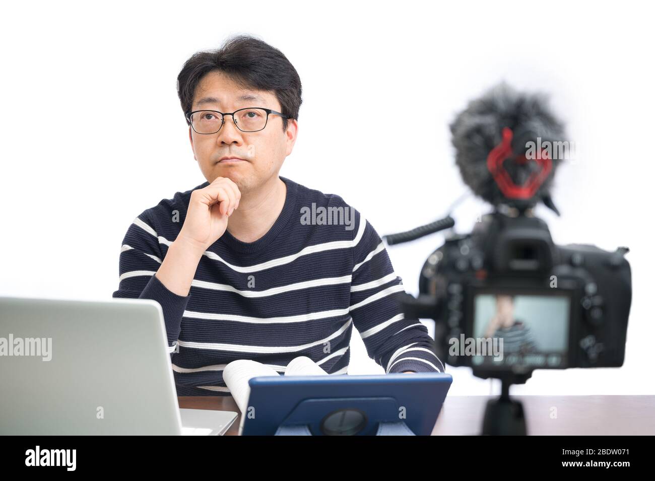 Online learning concept. An Asian middle-aged male teacher preparing to ...