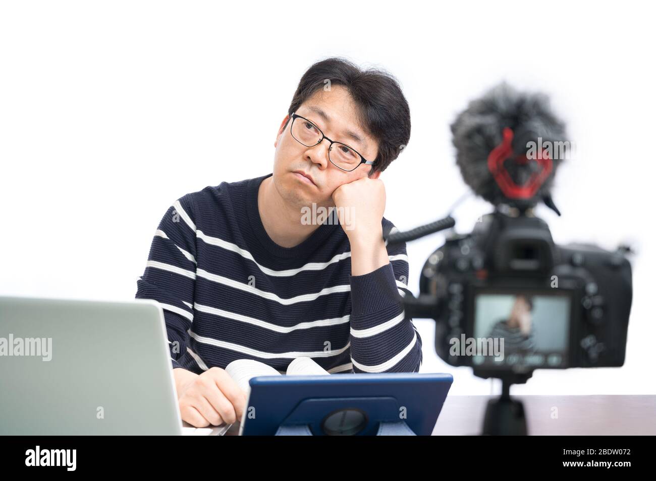 Online learning concept. An Asian middle-aged male teacher preparing to ...