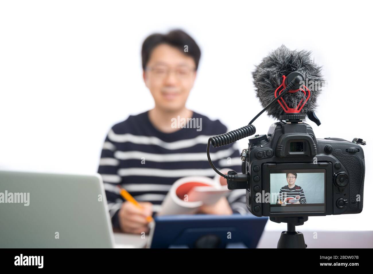 Online learning concept. An Asian middle-aged male teacher preparing to ...