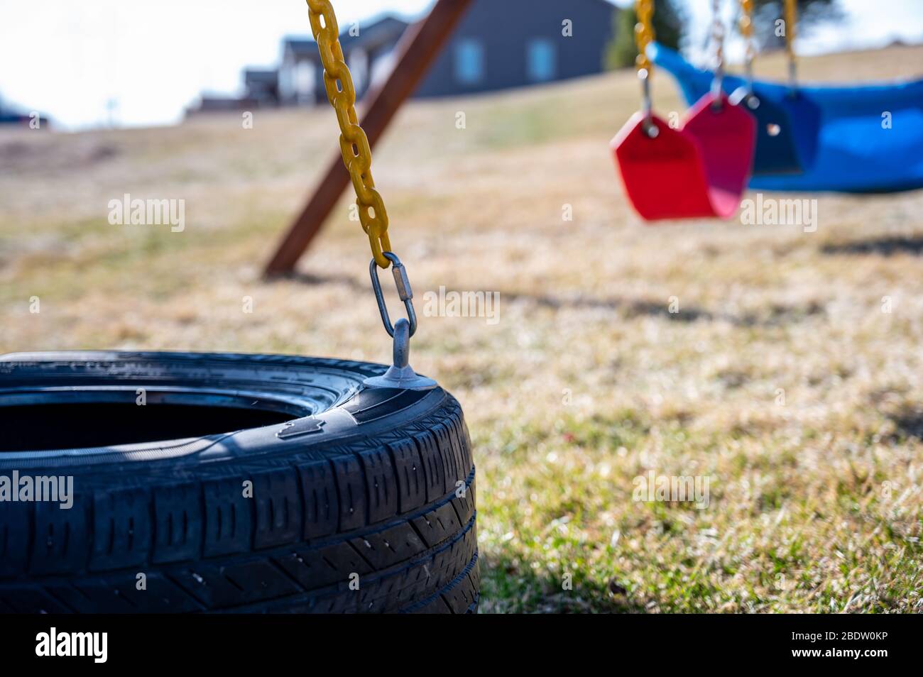 low angle view of tire swing with grass and swings in background Stock ...