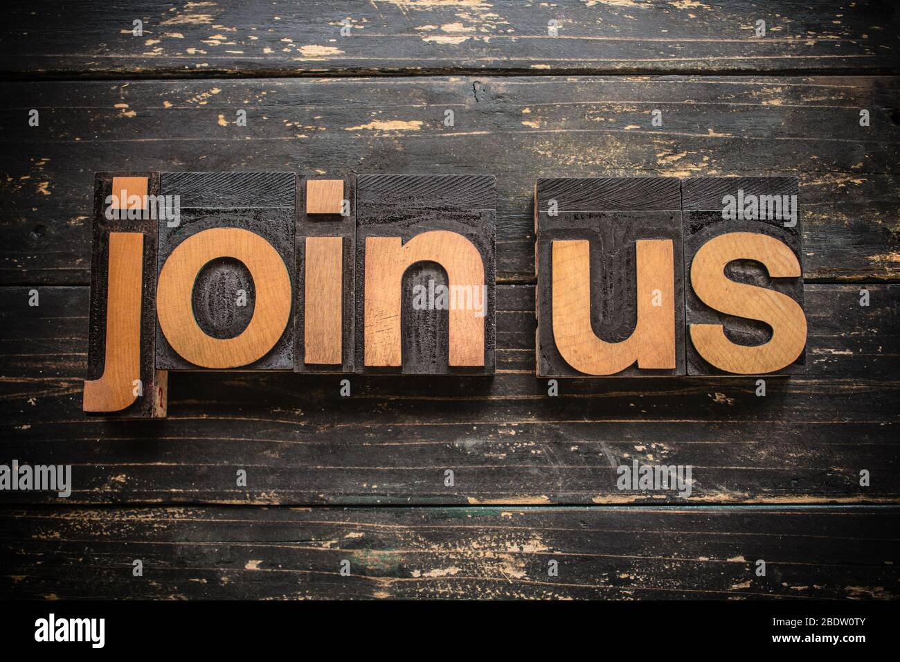The words "JOIN US" written in vintage wood letterpress type on a ...