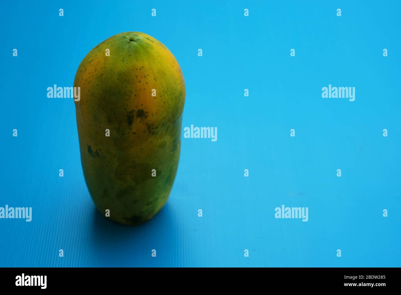 Papaya fruit in vertical line on blue background Stock Photo - Alamy