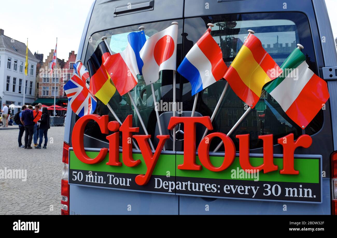 A city tour bus decorated with different nations' flags.Bruges.West ...