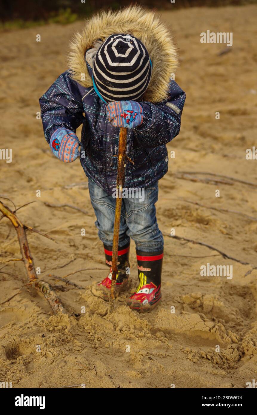 The child plays with the tree in the sand, resting, chill Stock Photo ...