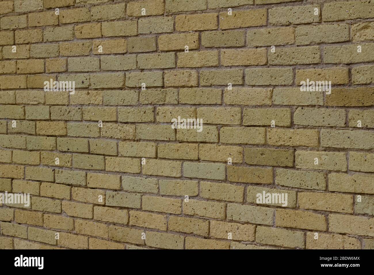 Shabby chic old yellow brick wall texture background, showing a pitted ...