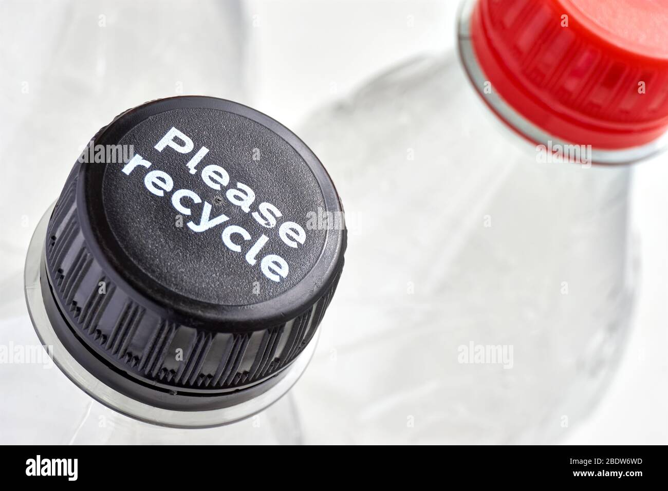 Plastic bottles and black and red bottle caps with please recycle ...