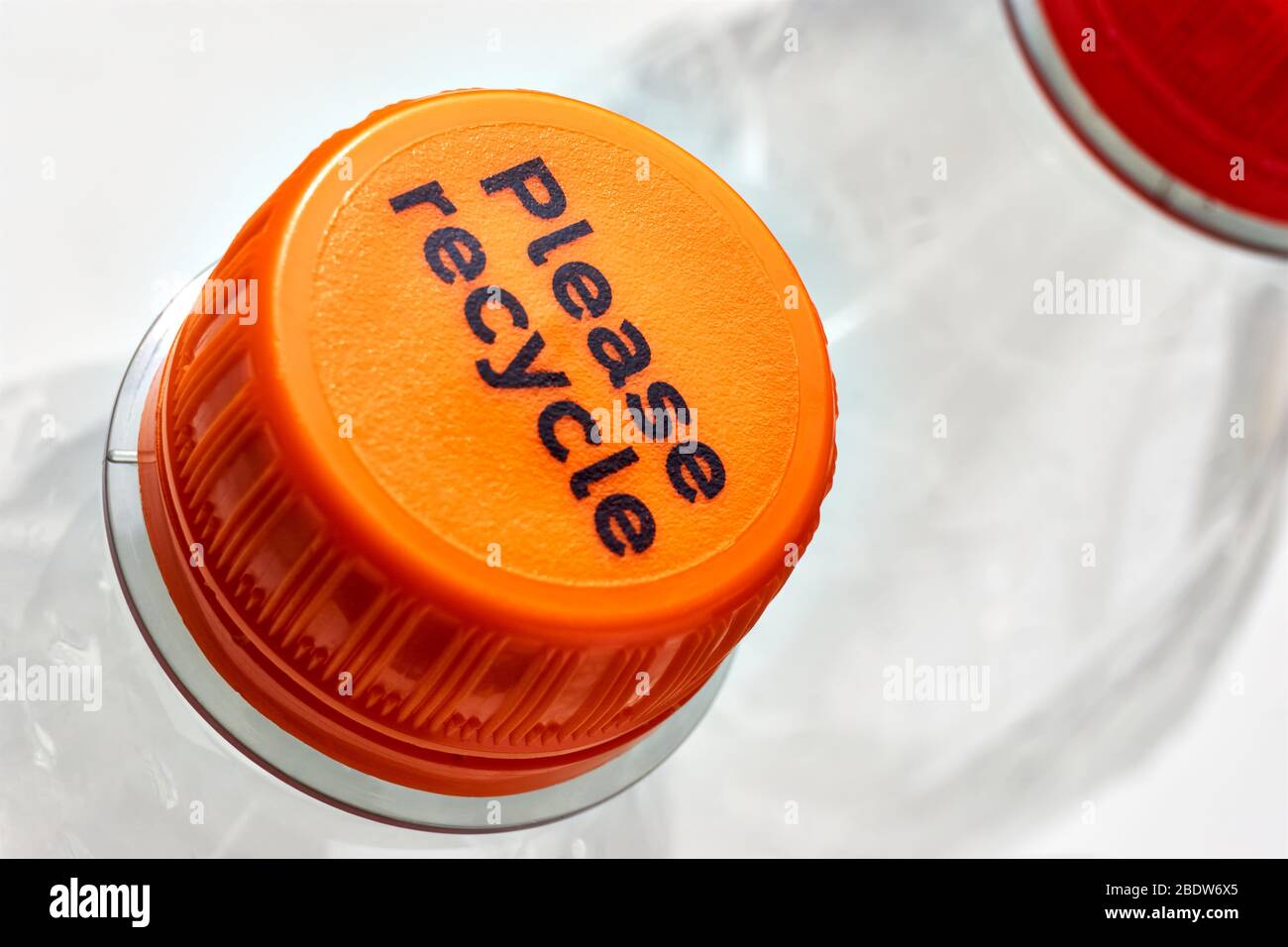 Plastic bottles and orange and red bottle caps with please recycle ...