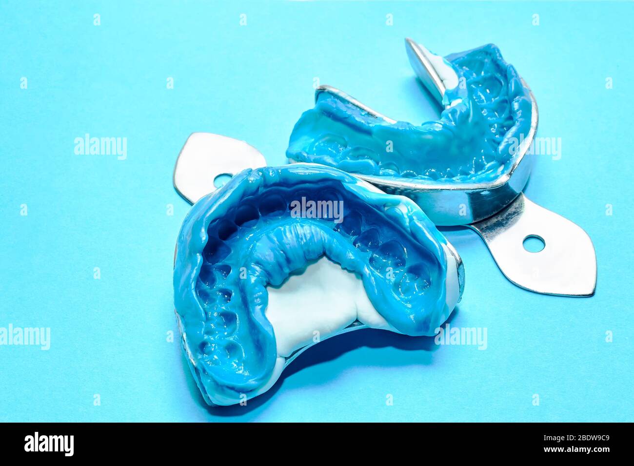 Two dental impressions on a blue background with copy space. Dental ...