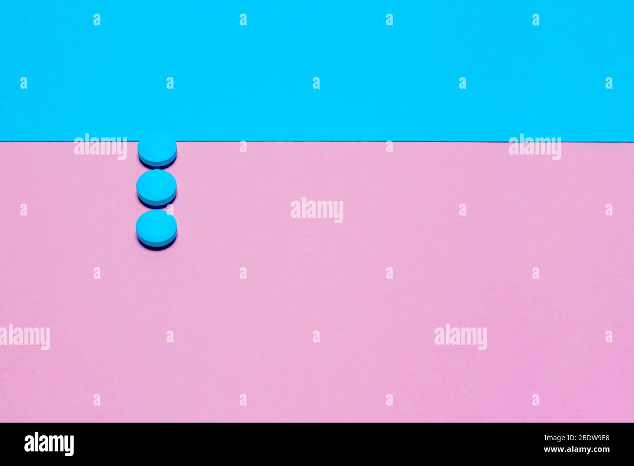 blue tablets on a paper background of blue and pink. Medication and ...