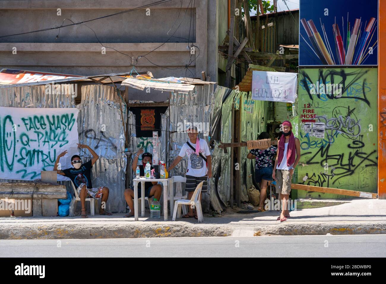 Local residents guard a makeshift barrier restricting entry to a poor ...