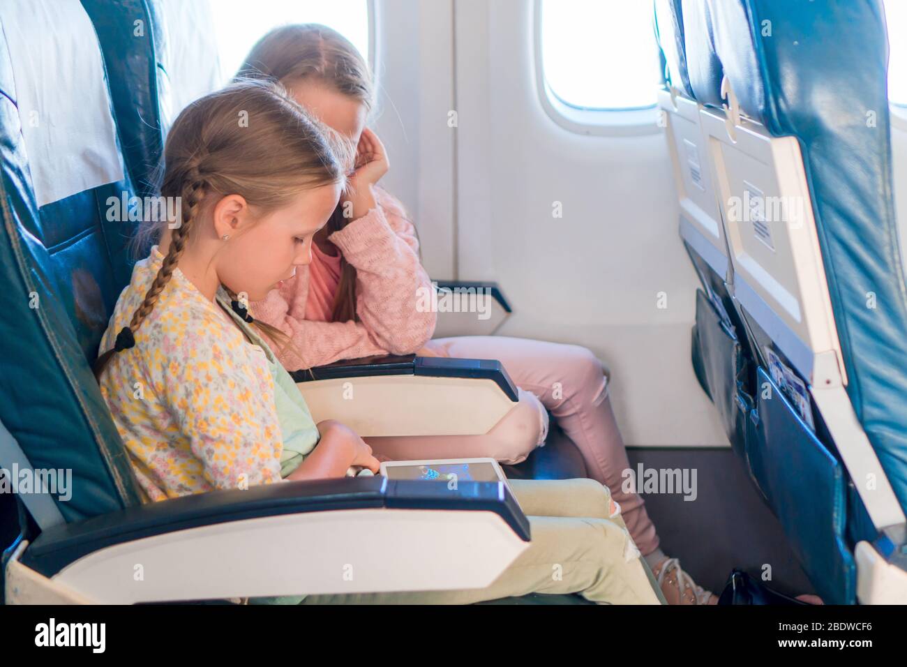 Adorable little girls traveling by an airplane Stock Photo - Alamy