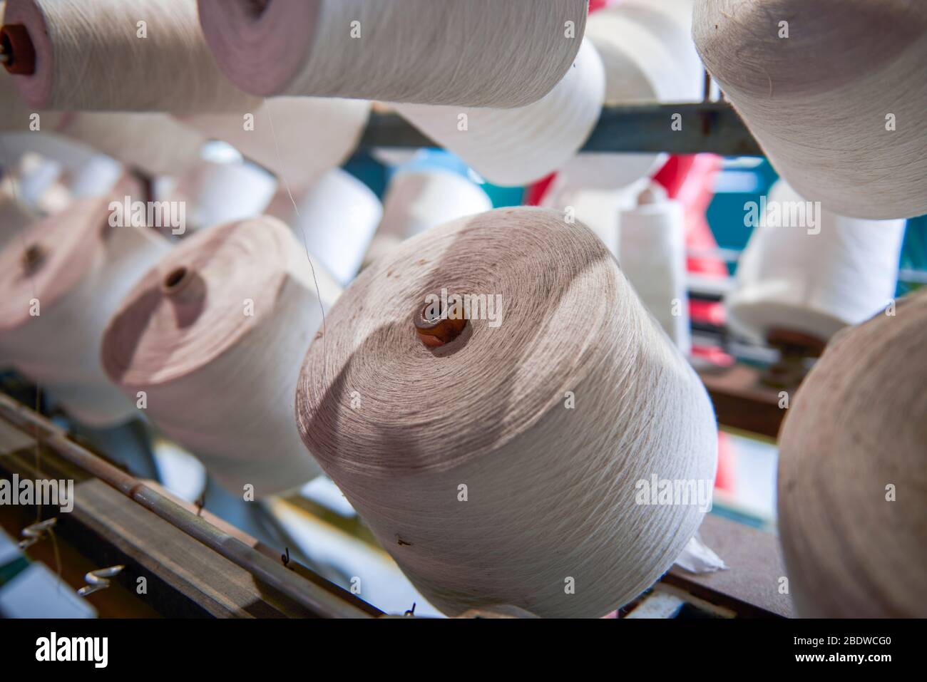 A row of bobbins on a cotton spinning machine Stock Photo - Alamy