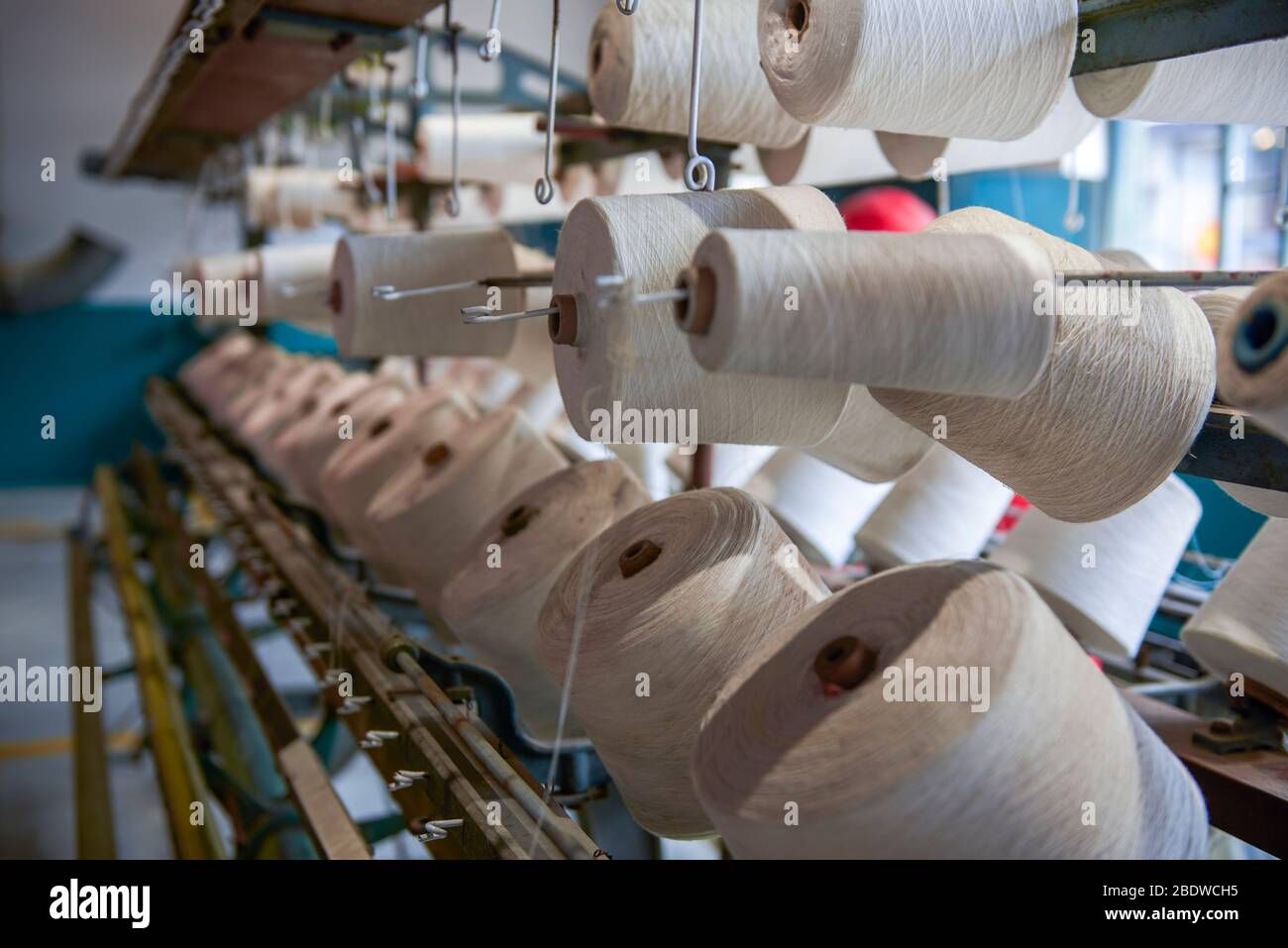 A row of bobbins on a cotton spinning machine Stock Photo - Alamy