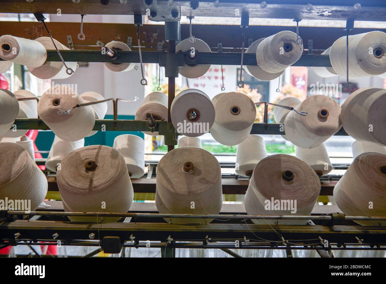 A row of bobbins on a cotton spinning machine Stock Photo - Alamy